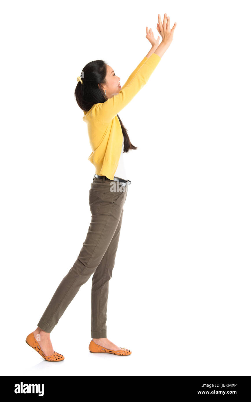 Side view or profile of an Asian girl arms up like pushing something ...