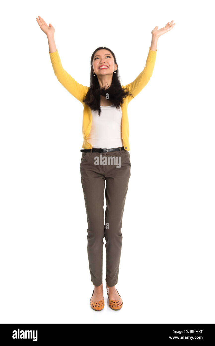 Asian girl arms up, looking upwards like holding something above, full ...