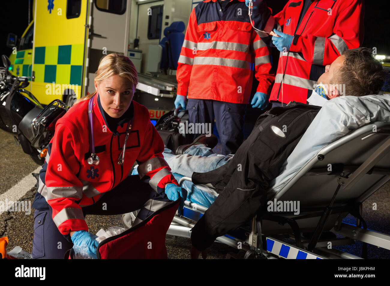 Paramedics assisting injured motorcycle man driver on stretcher at ...