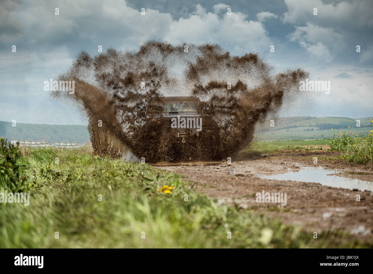 Off road car in muddy road splashing mud Stock Photo - Alamy