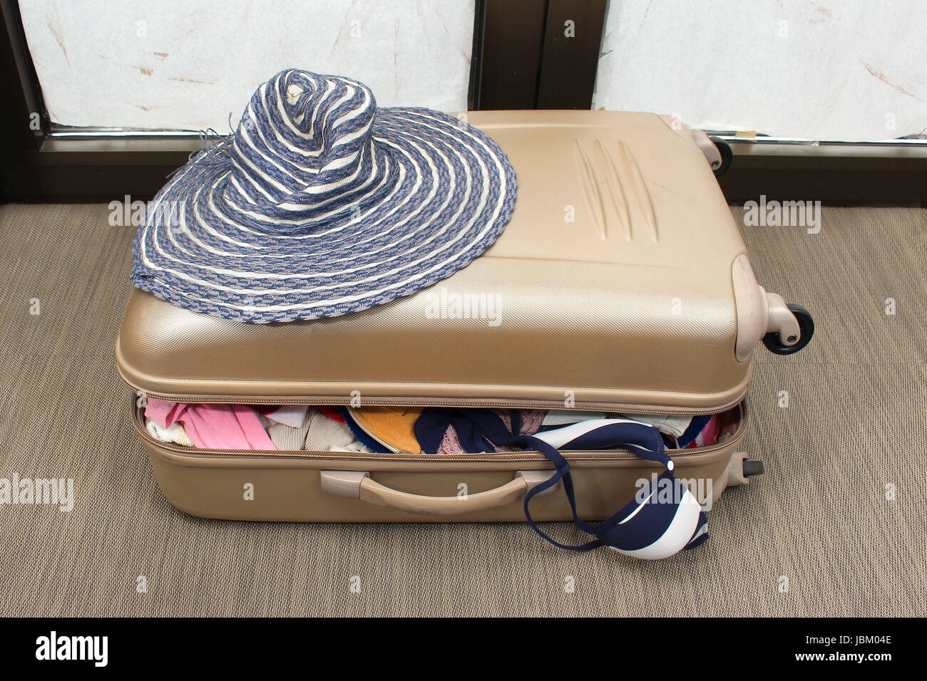 Overfilled suitcase with clothes packed for summer vacation Stock Photo ...