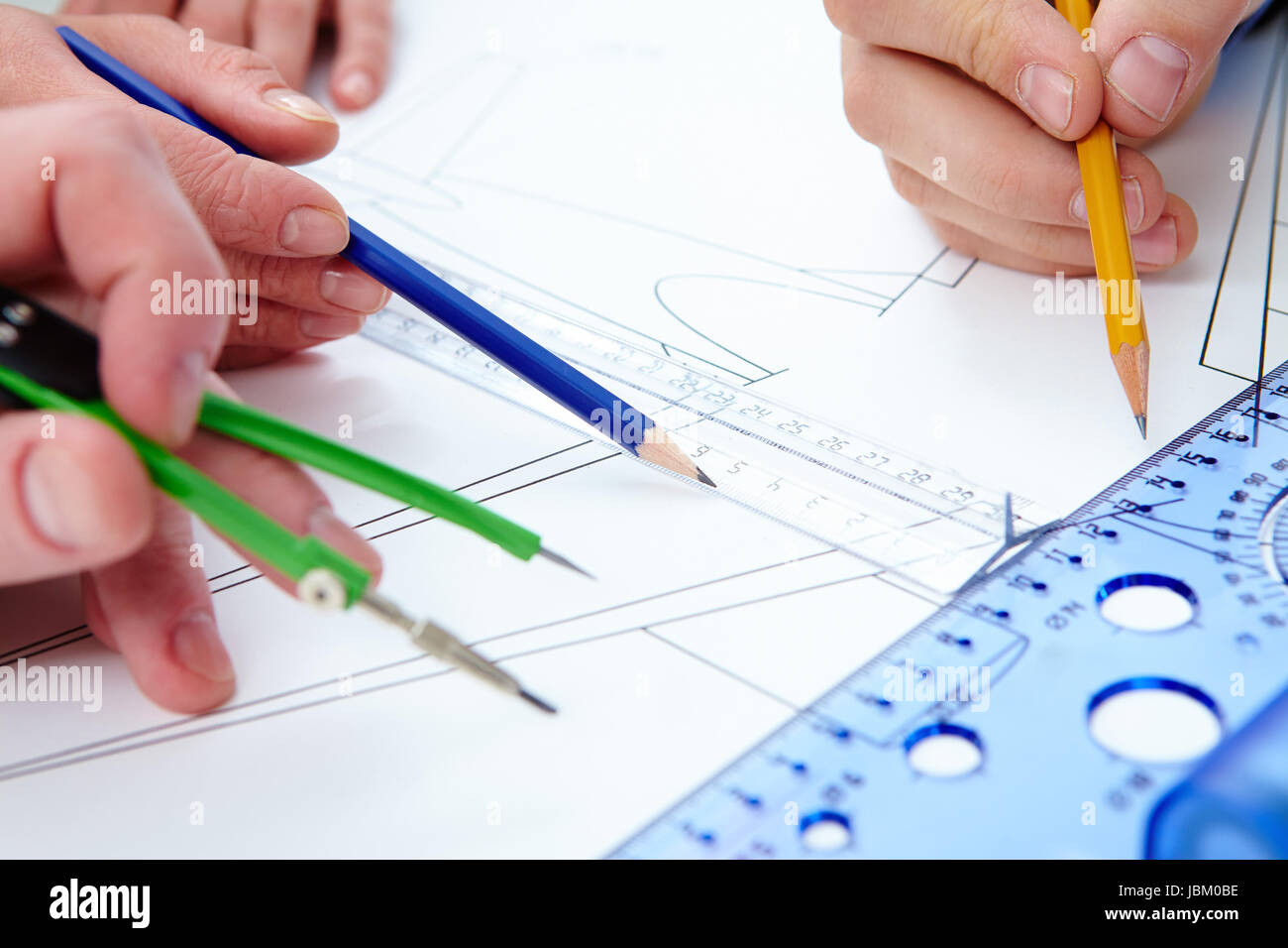 Close-up of three hands with ruler and pencils over draft Stock Photo ...