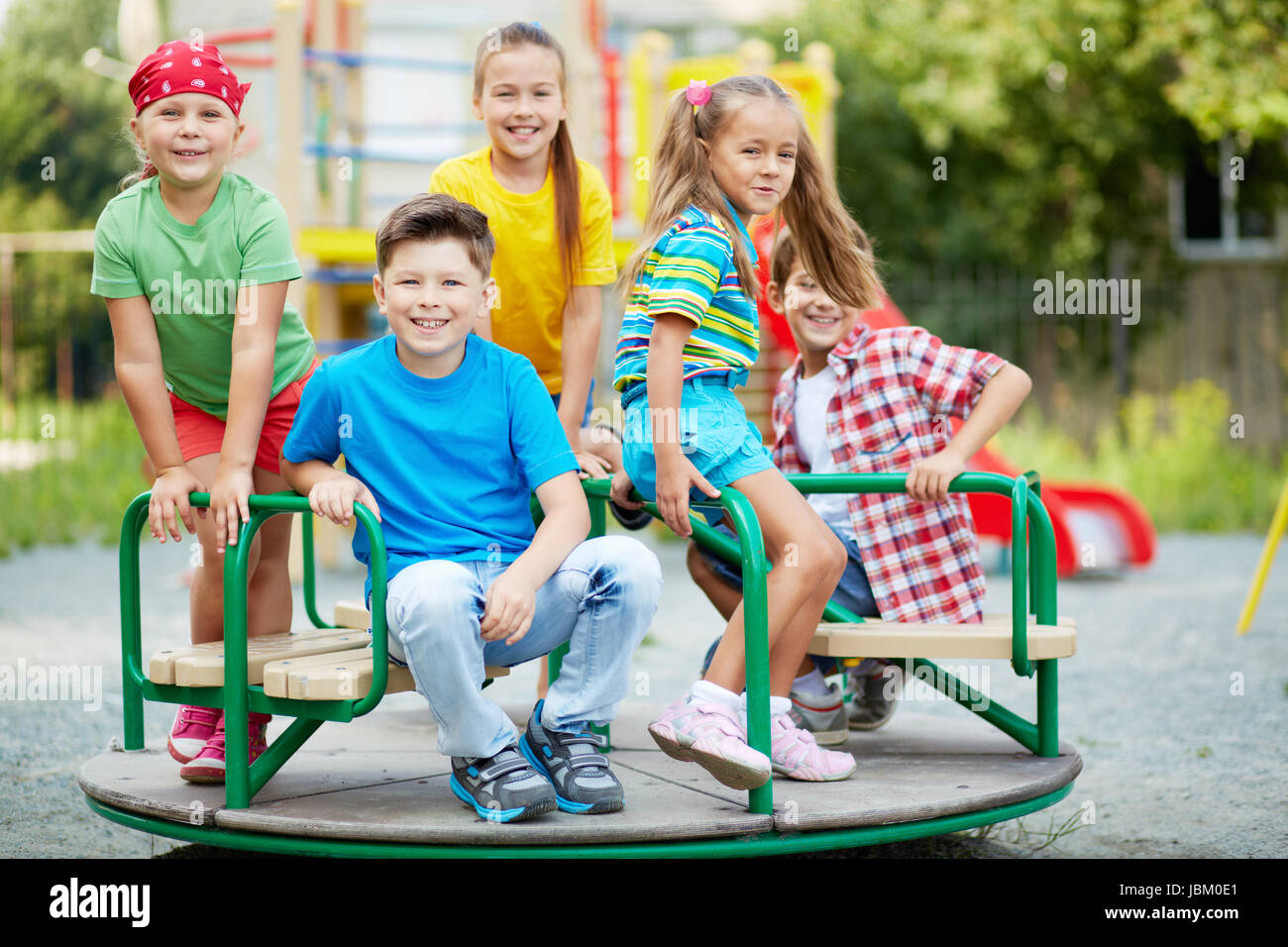 Image of cute friends having fun on carousel outdoors Stock Photo - Alamy