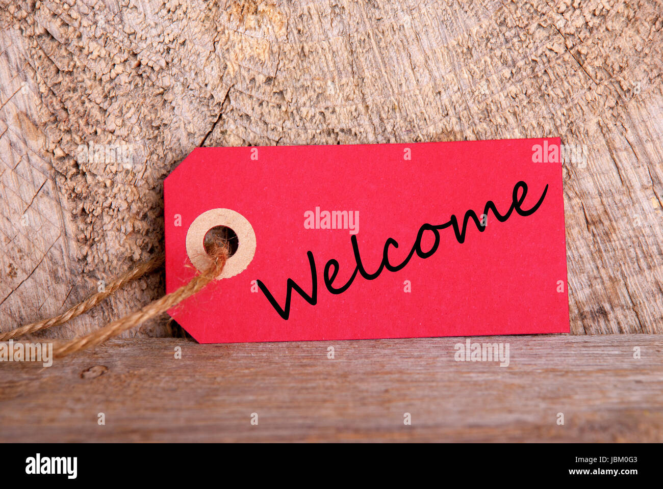 A Red Tag with the Word Welcome on Wood Stock Photo - Alamy