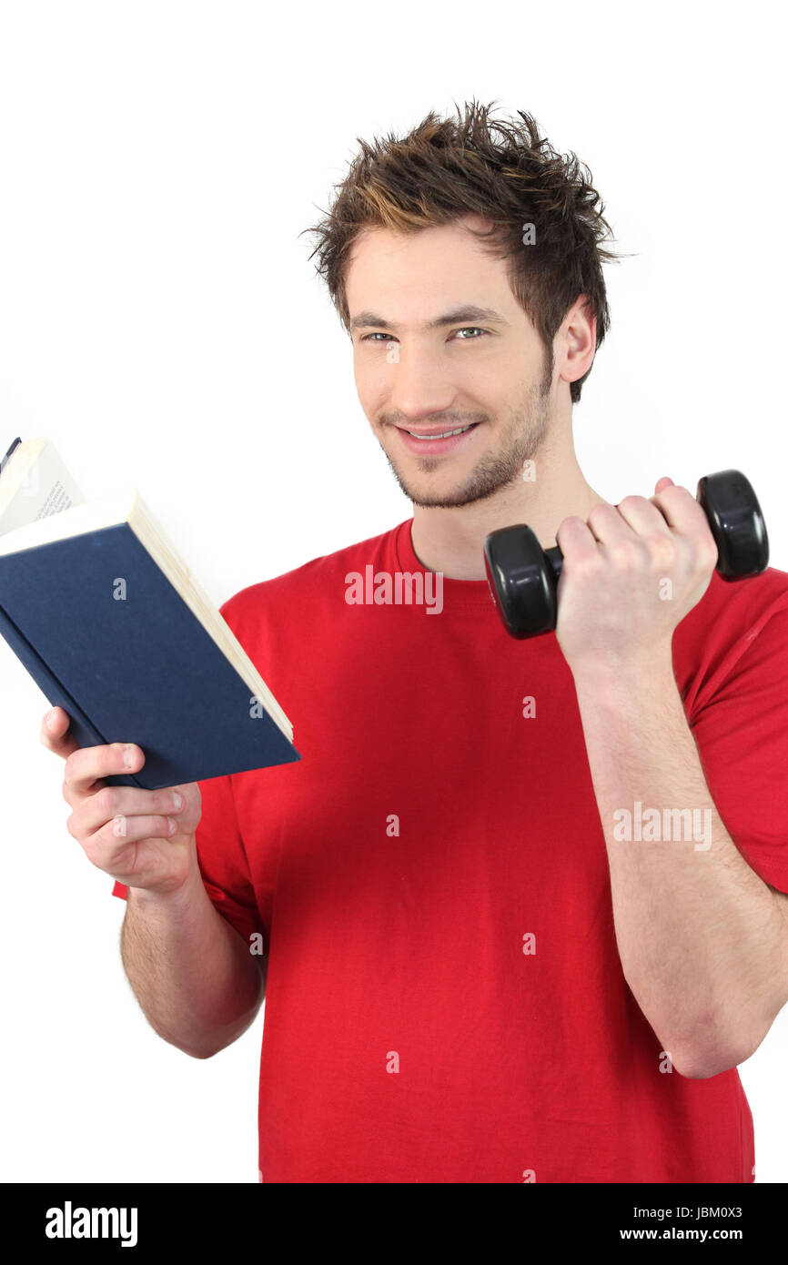 Man reading book whilst lifting weights Stock Photo - Alamy