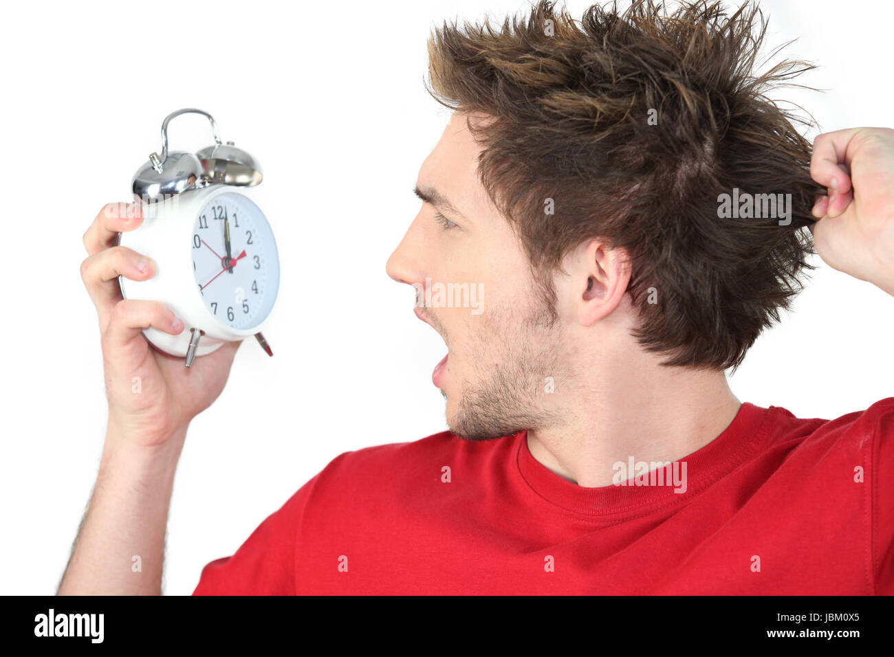 Man screaming with alarm clock in hand Stock Photo - Alamy