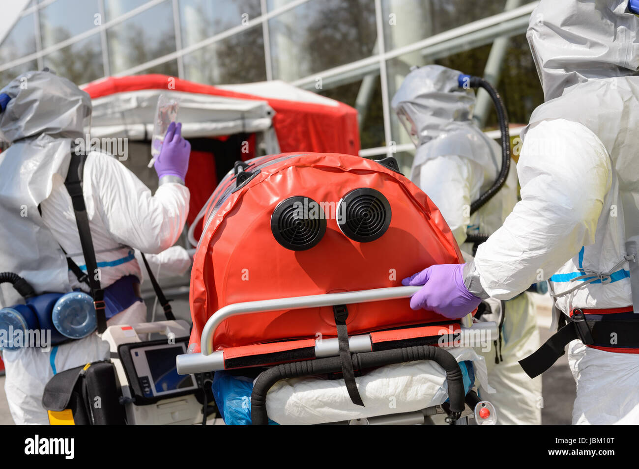 Biohazard medical team pushing stretcher towards decontamination ...