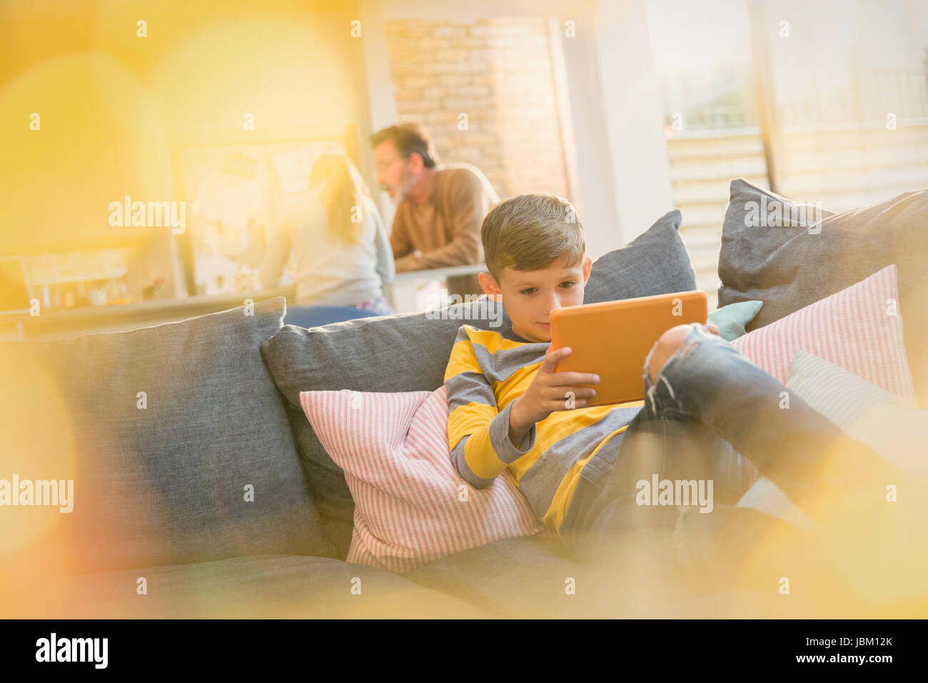 Boy using digital tablet on sofa Stock Photo - Alamy