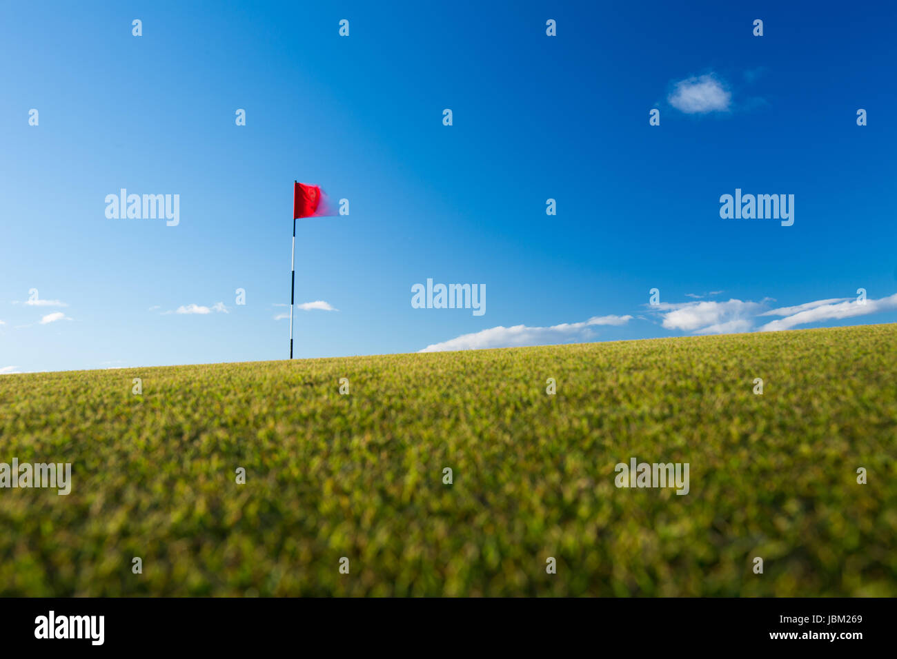 Red golf flag on a golf course, moving in the wind (motion blurred ...