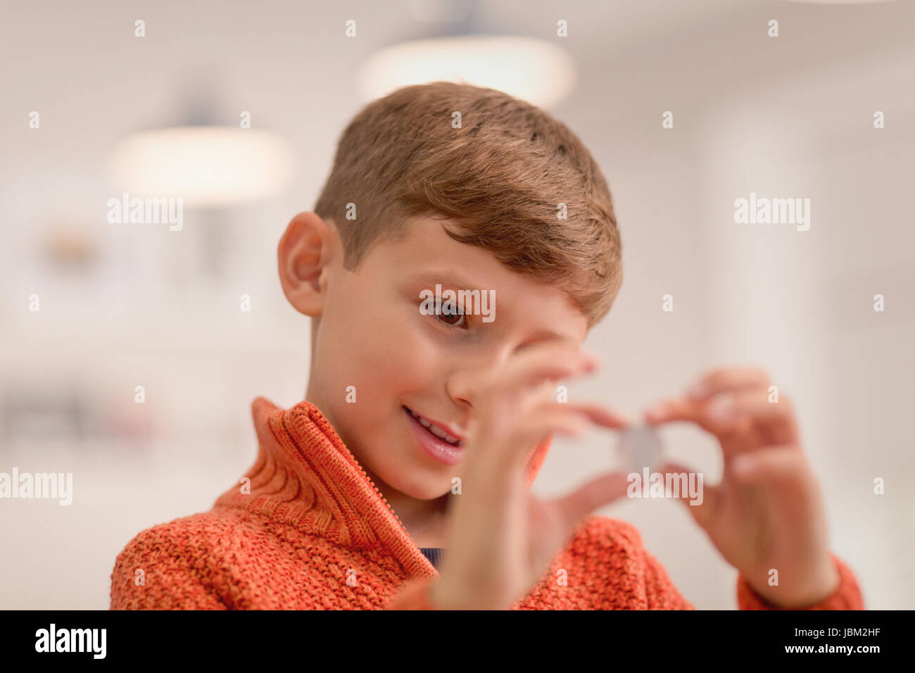 Curious boy holding coin Stock Photo - Alamy