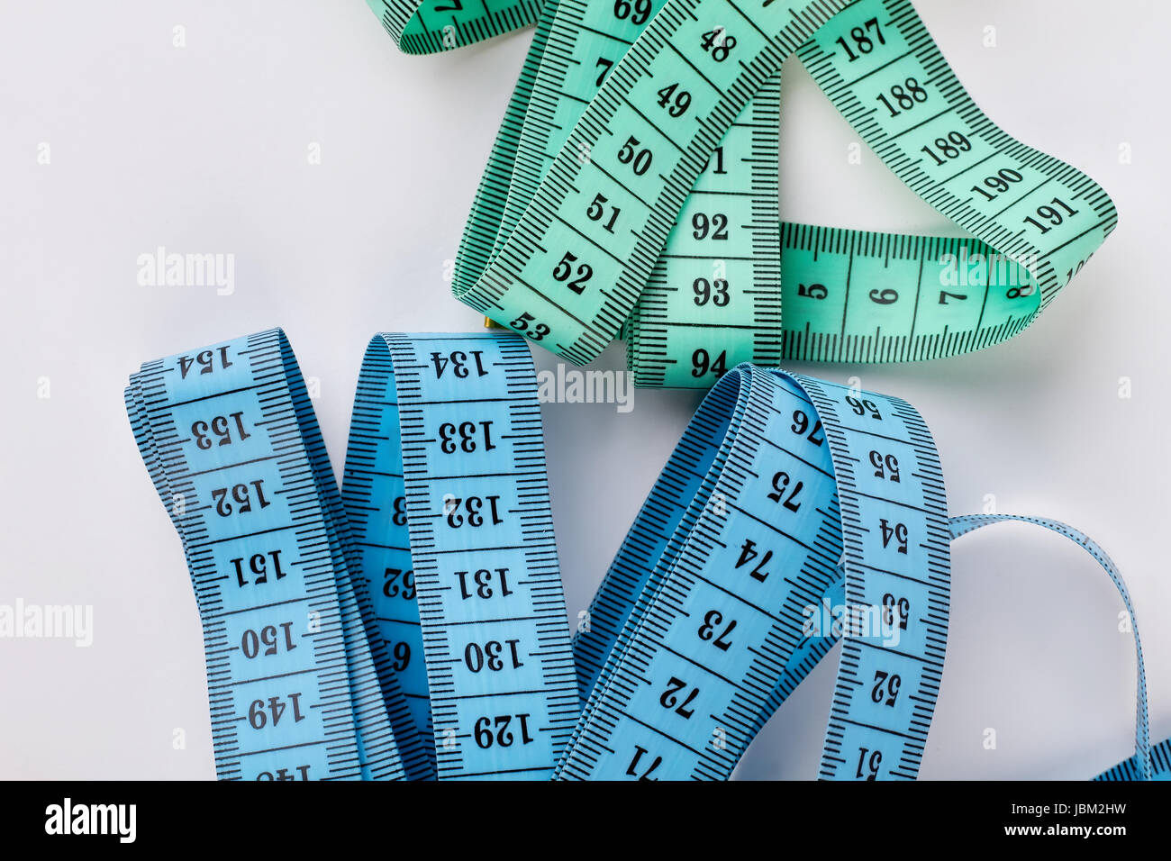 Two measuring tapes, white background Stock Photo - Alamy