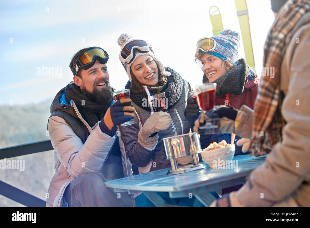 Skier friends drinking and eating at balcony table apres-ski Stock ...