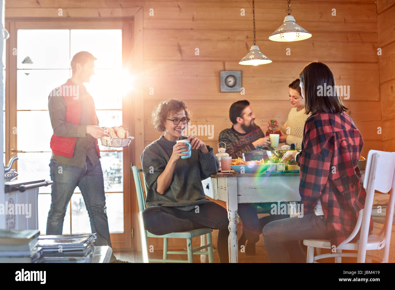 Friends eating and hanging out at cabin table Stock Photo - Alamy