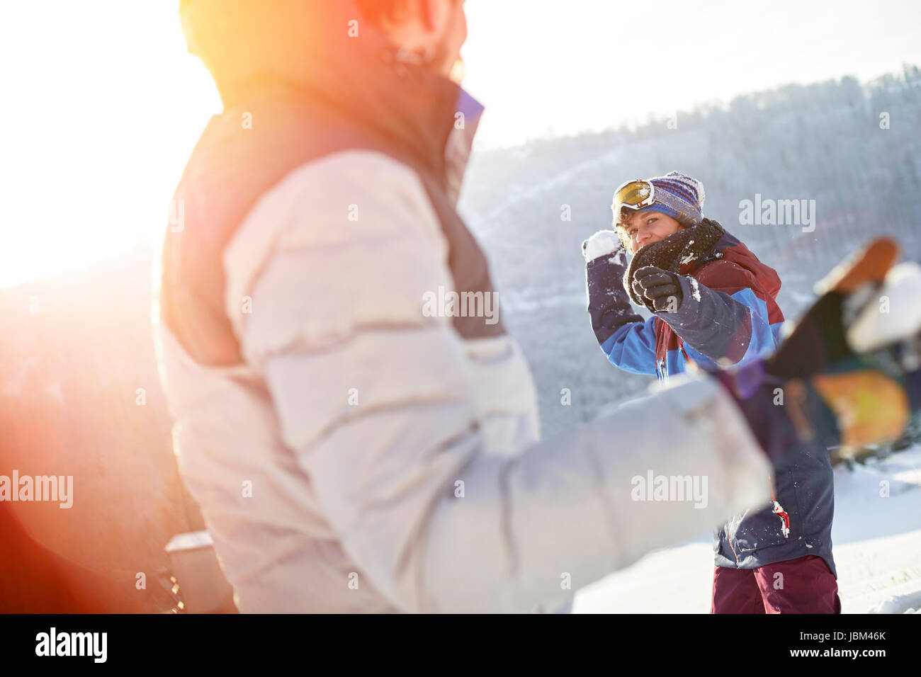 Friends enjoying snowball fight in sunny, snowy field Stock Photo - Alamy