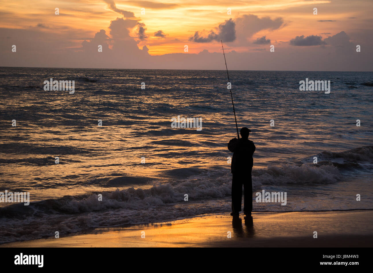 Fisherman trying his luck at dusk Stock Photo - Alamy
