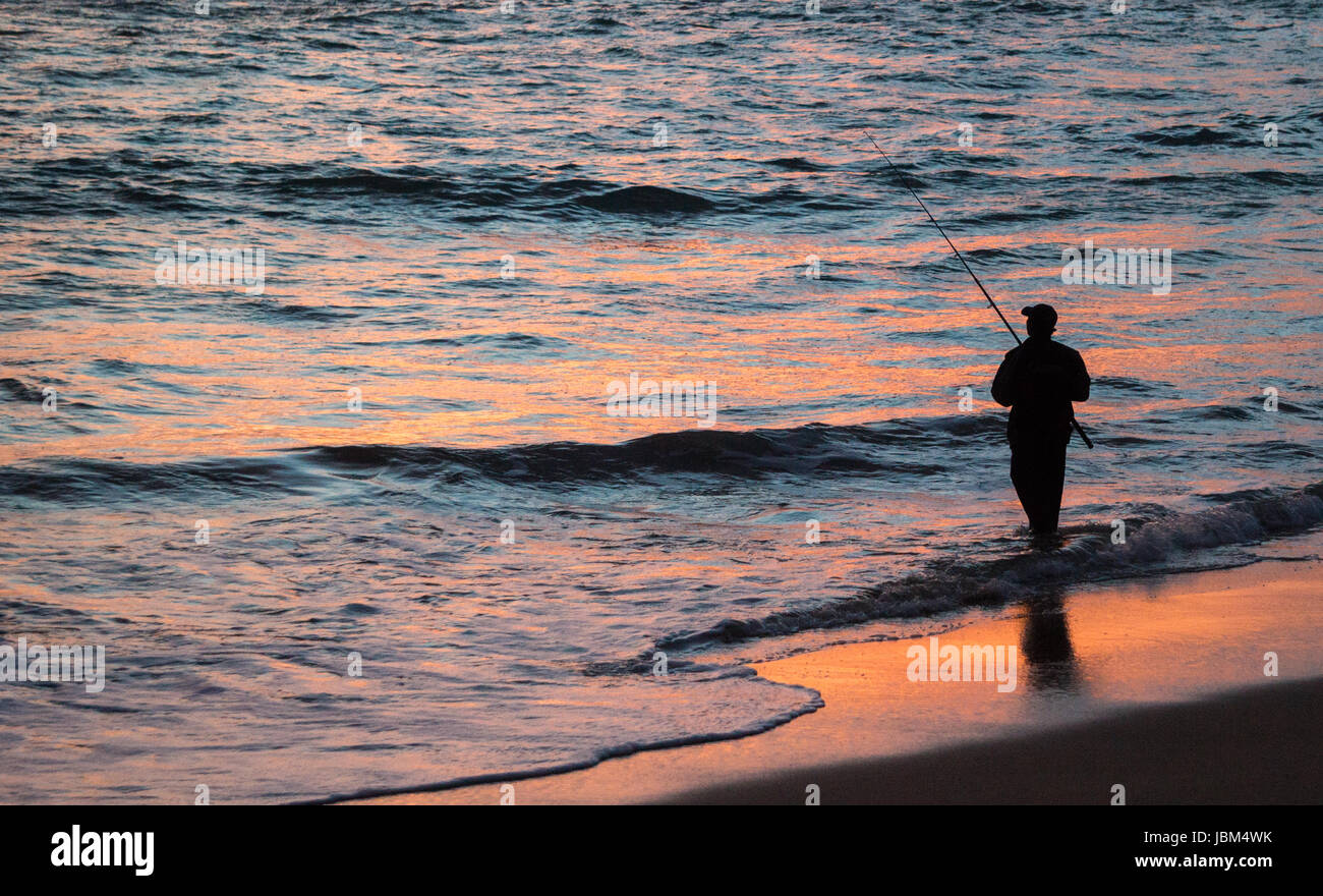 Fisherman trying his luck at dusk Stock Photo - Alamy