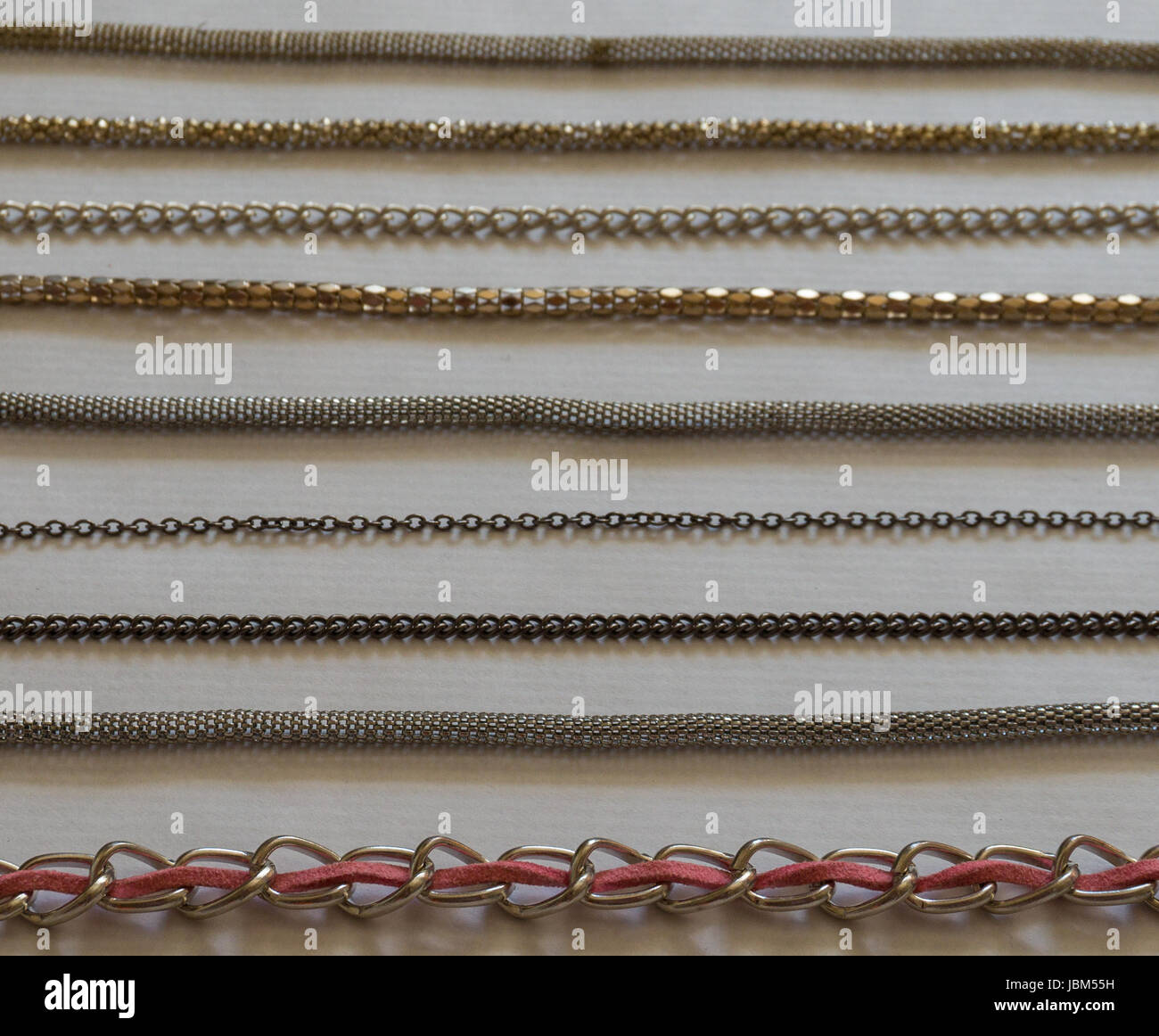 Rows of different chains with white background Stock Photo - Alamy