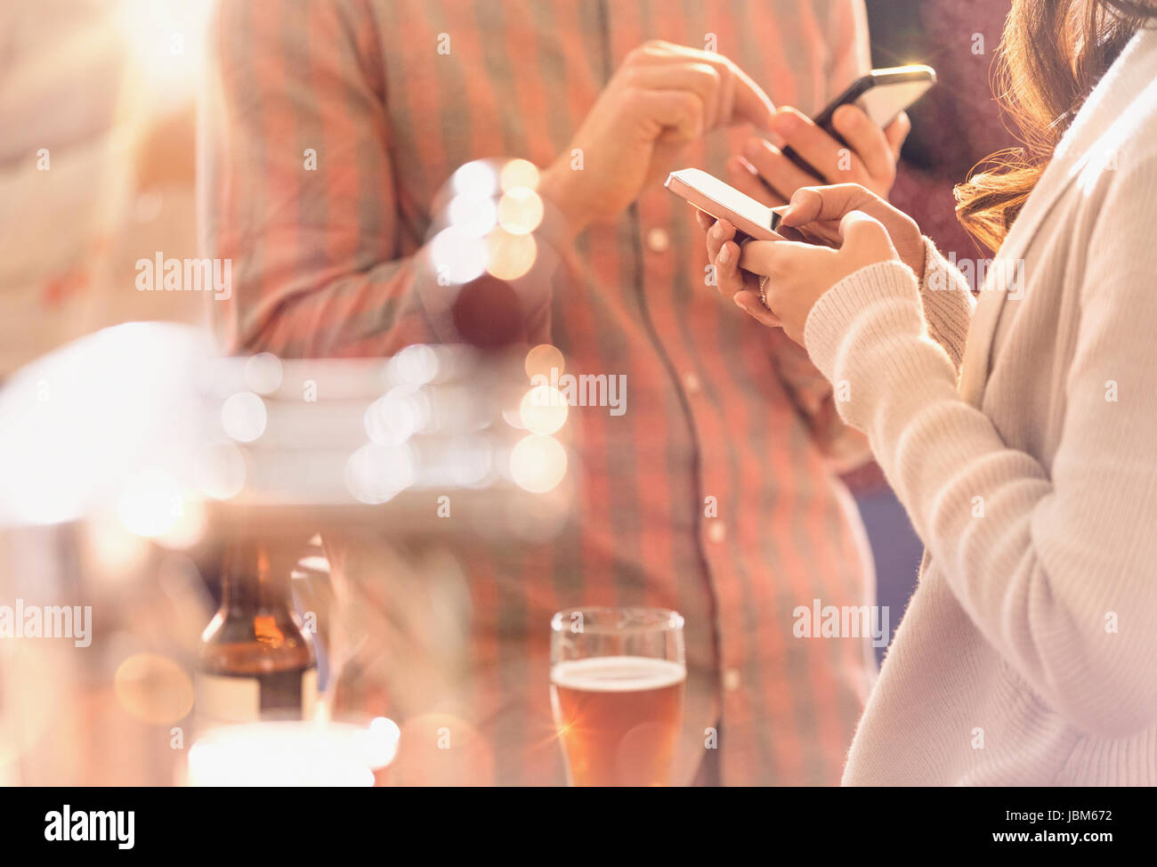 Man and woman texting with cell phone and drinking beer at bar Stock ...