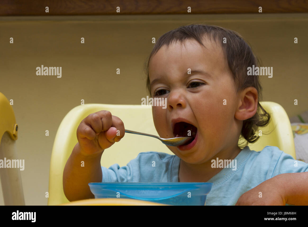 baby eating food on kitchen Stock Photo - Alamy