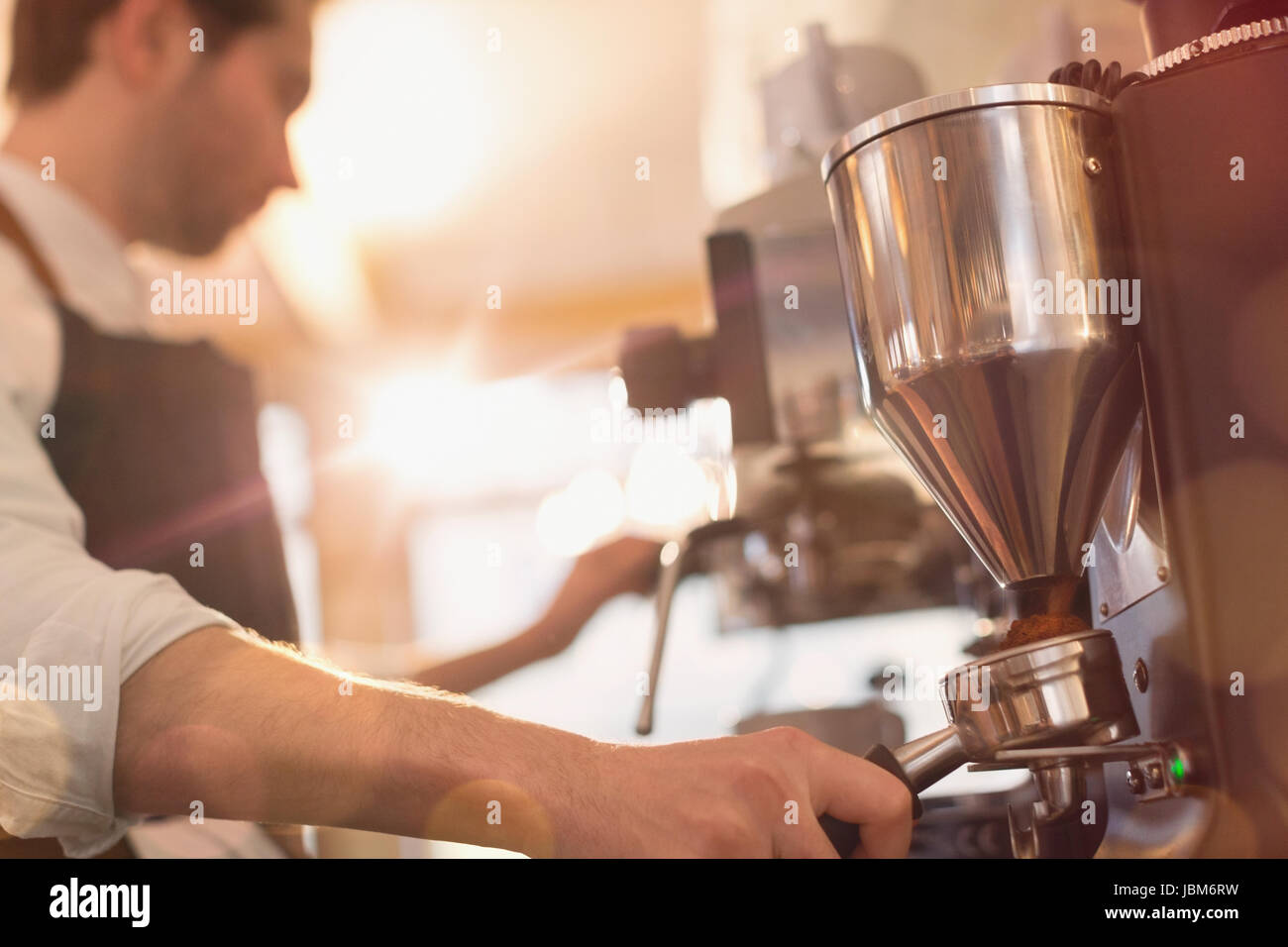 Barista using espresso machine grinder in cafe Stock Photo - Alamy