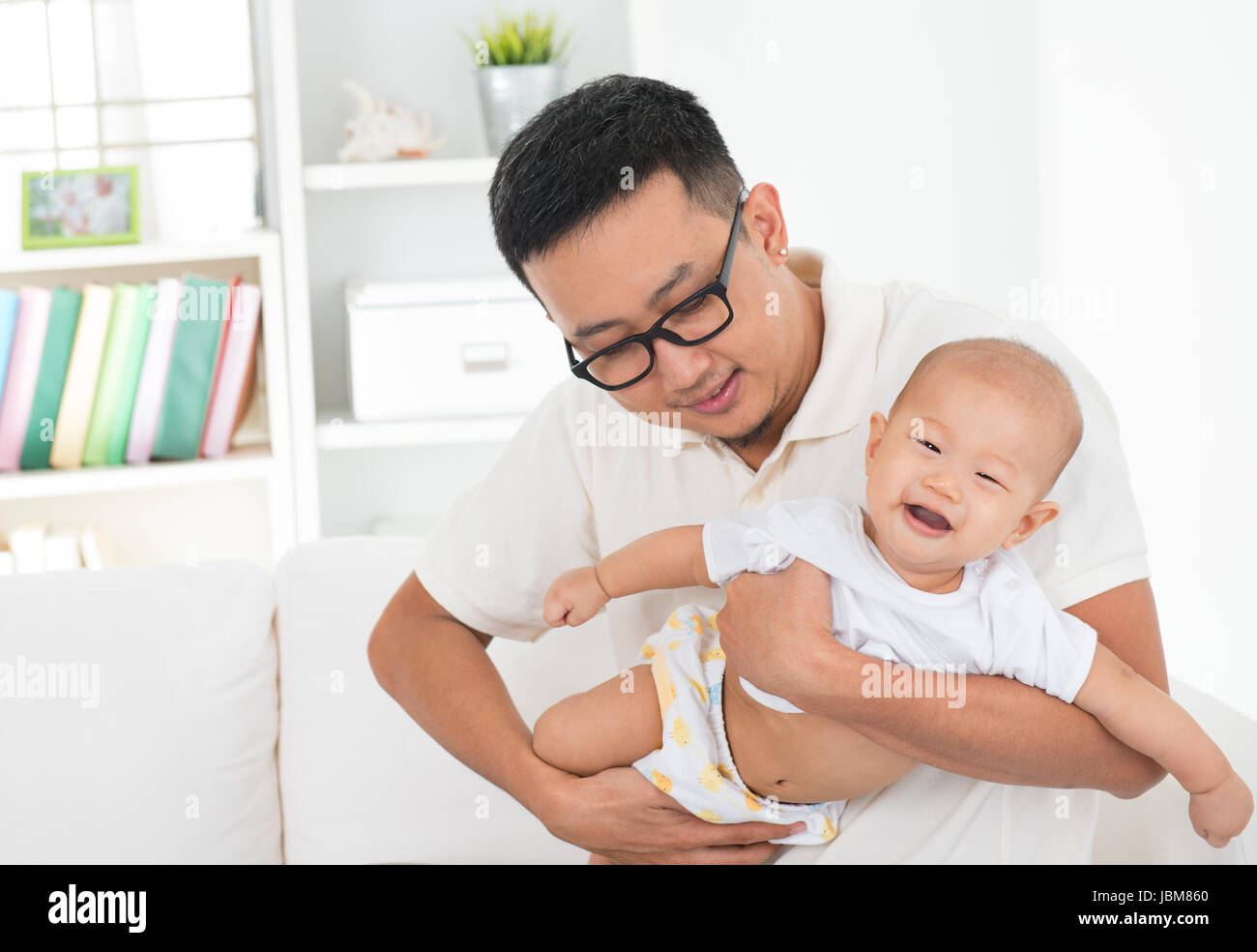 Asian family lifestyle at home. Father flying baby boy, having fun time ...