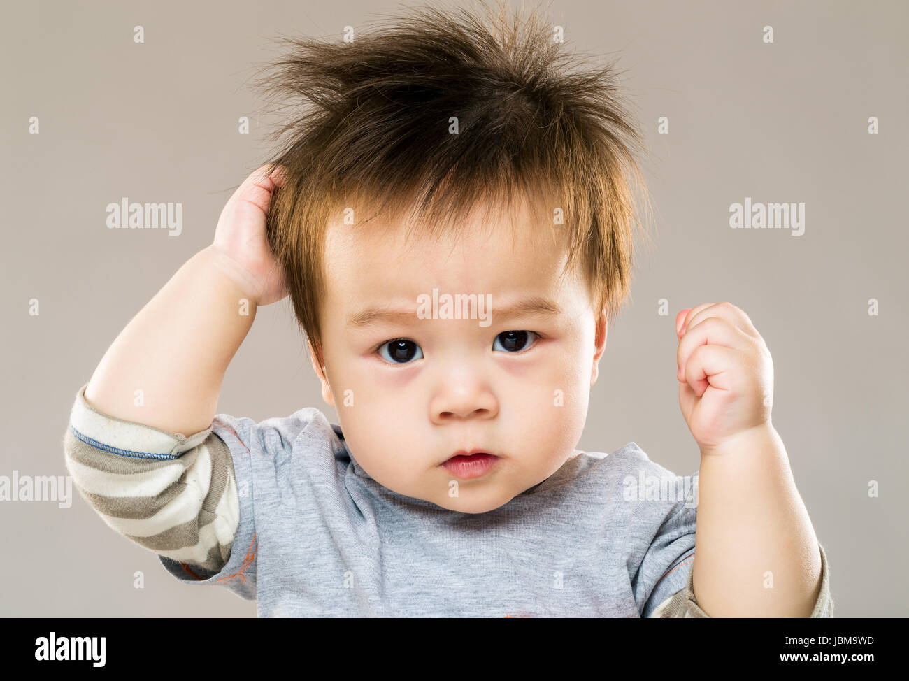 Asian serious kid with grey background Stock Photo - Alamy