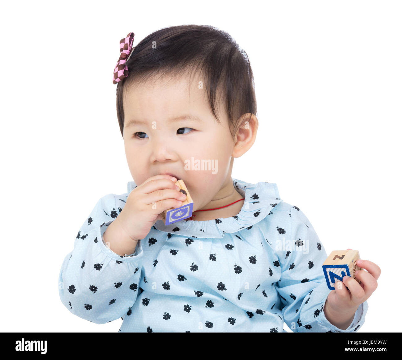 Little girl bite toy block Stock Photo - Alamy