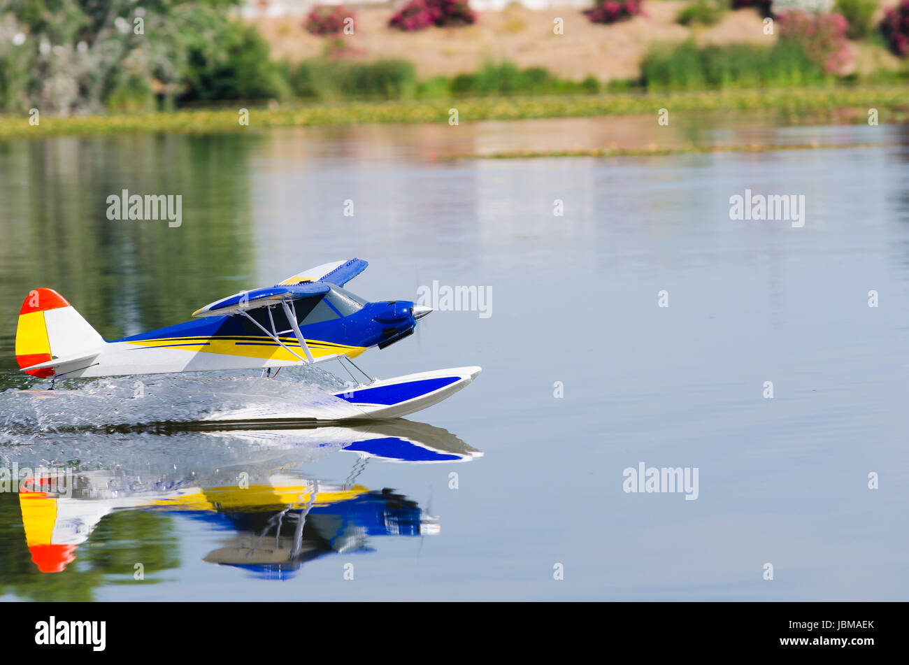 A floating Radio controlled model seaplane speeds up to take off on ...