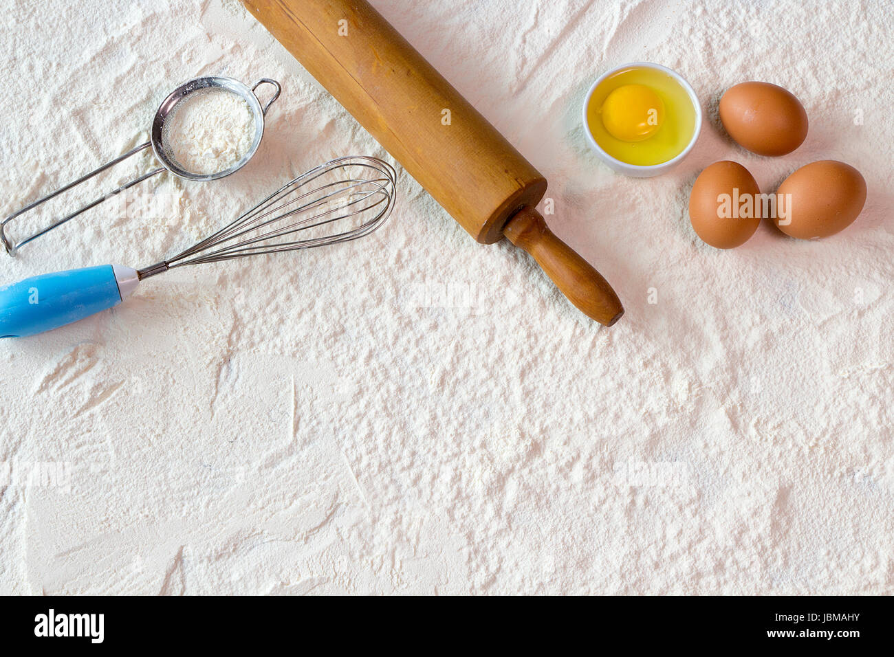 Baking background. white flour, eggs , whisk , sieve, and rolling pin ...