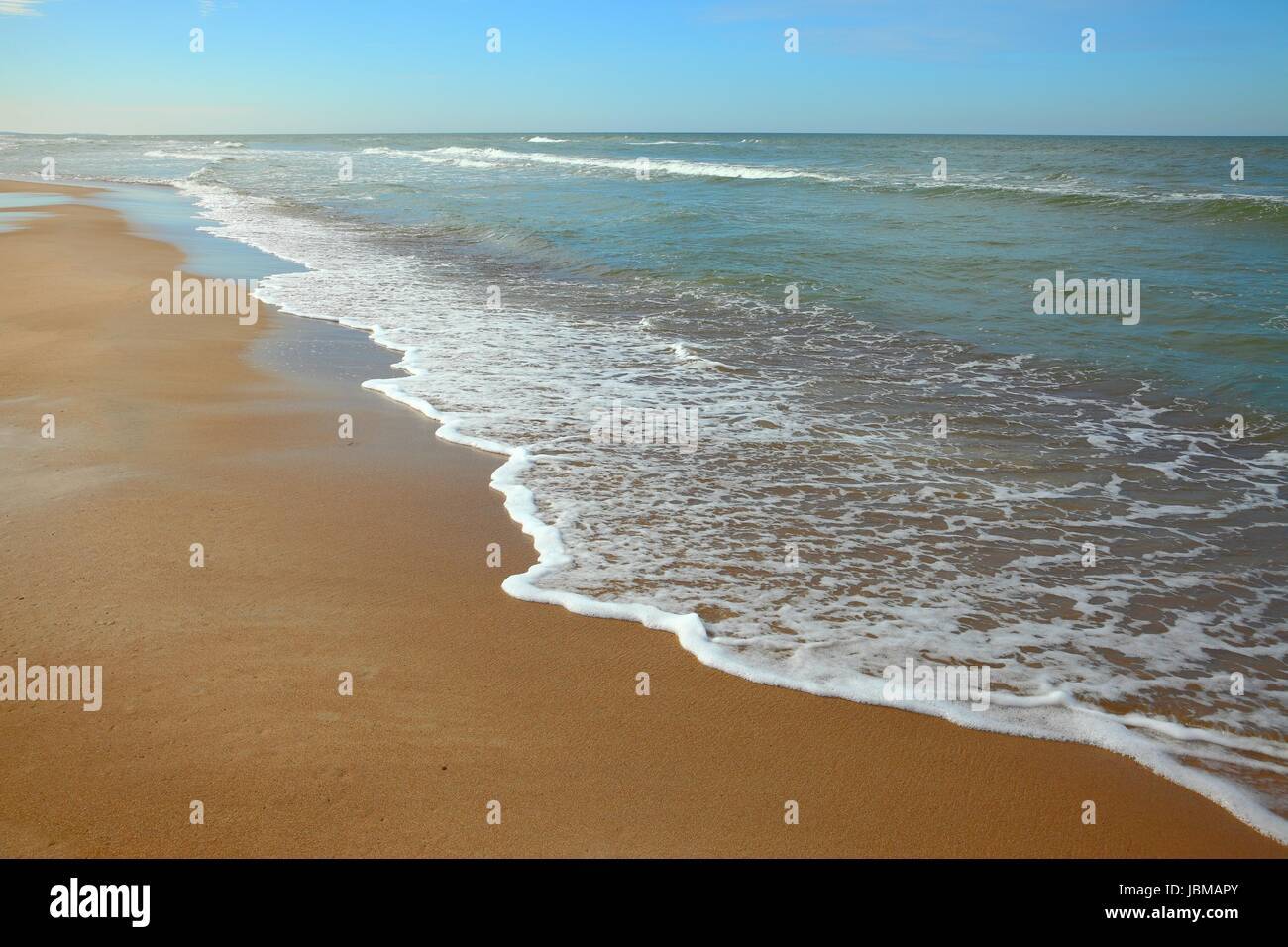 Sandy beach with waves of the see Stock Photo - Alamy