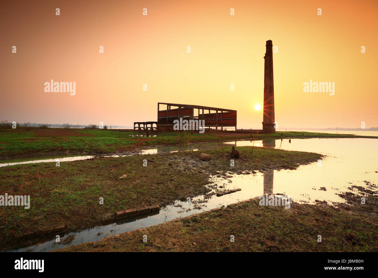 Old decaying factory building with reflections in lake. Old factory on ...