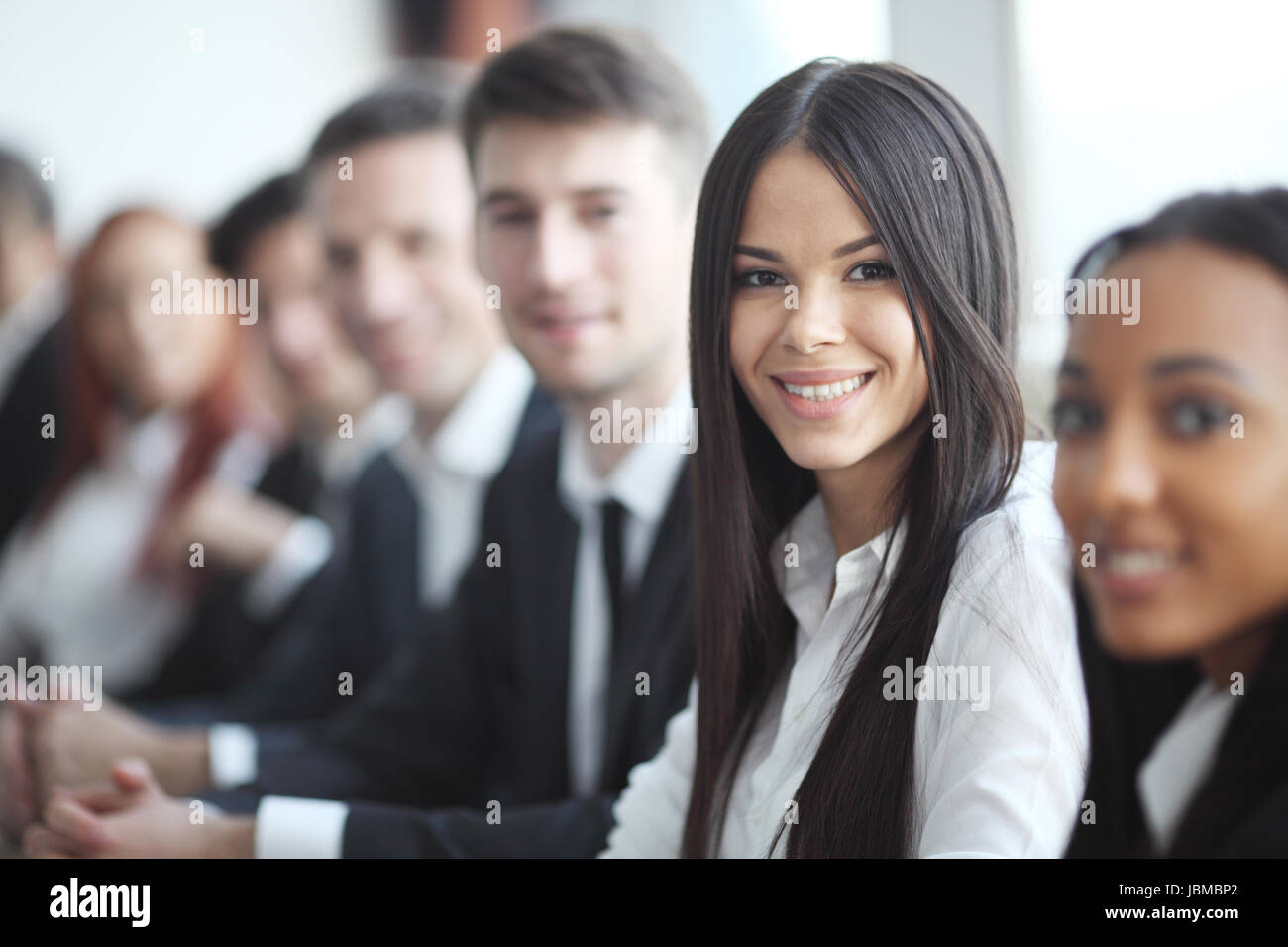 Business people sitting in a row and working, focus on pretty woman ...
