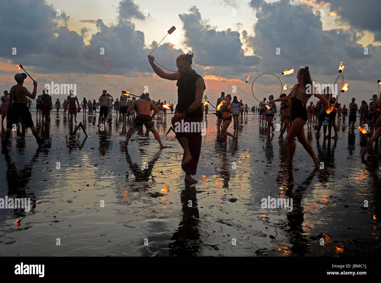 Fire dancers perform on the beach at sunset at the 2015 Envision ...