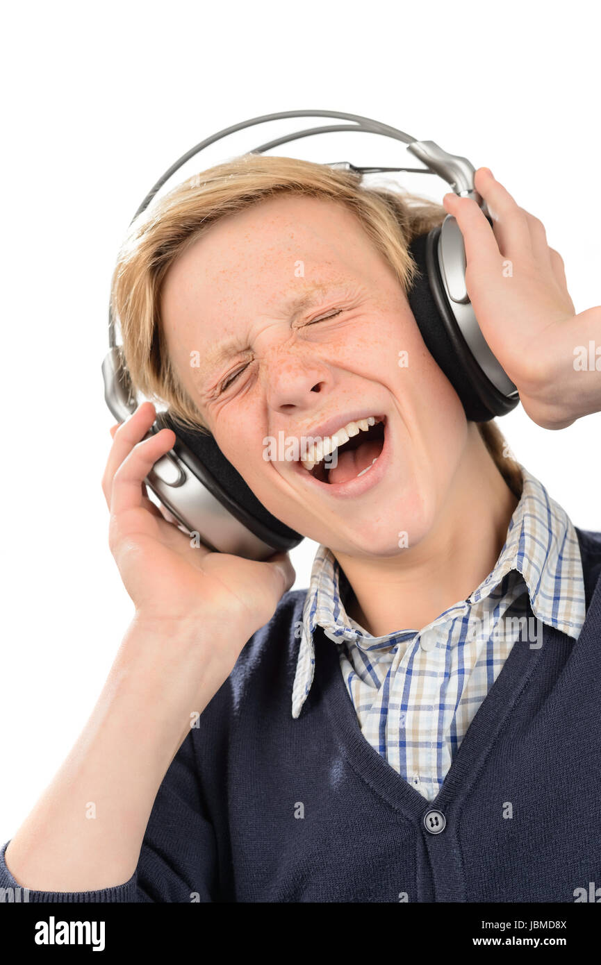 Cheerful teenage boy singing while enjoying music from headphones ...