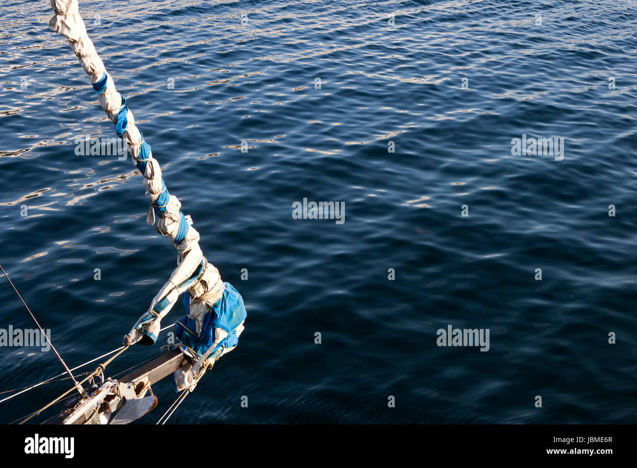 Furled staysail jib in the bowsprit of the bow of a yacht in the sea ...