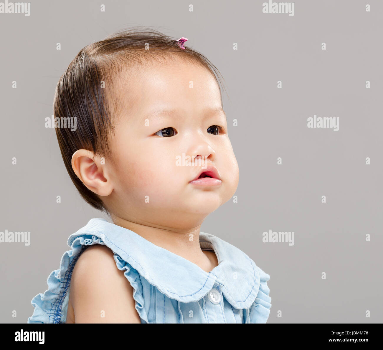 Baby girl looking at aside Stock Photo - Alamy