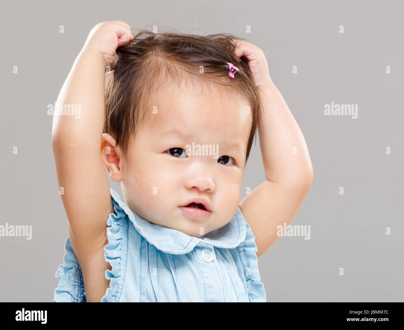 Baby scratching hair Stock Photo - Alamy