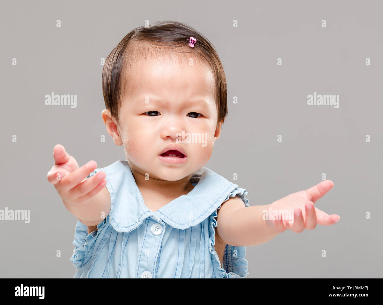 Baby with hand up Stock Photo - Alamy