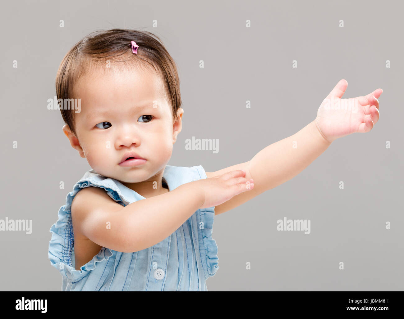 Baby girl with hand up Stock Photo - Alamy