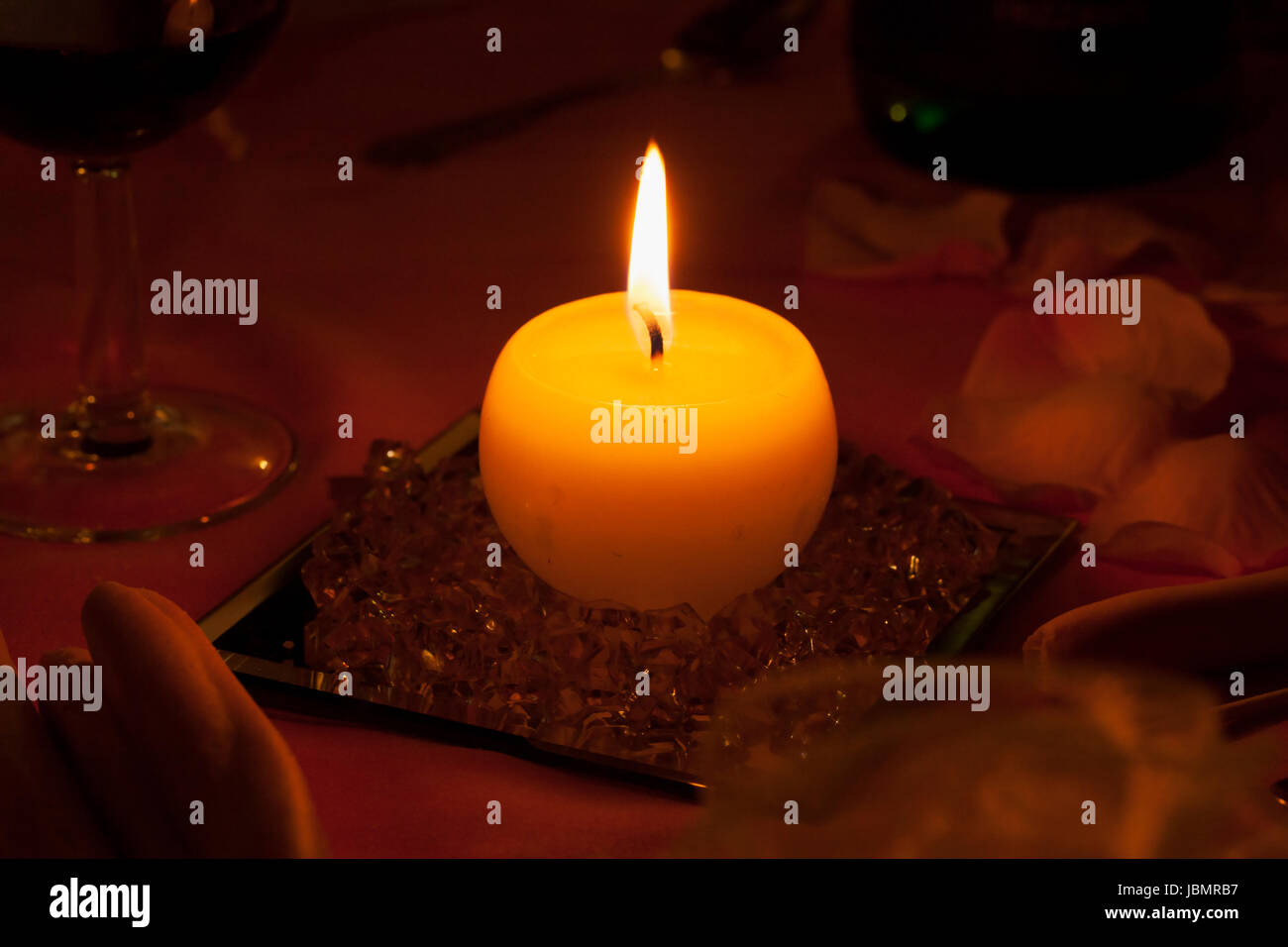 Lit candle in the middle of a lunch table Stock Photo - Alamy