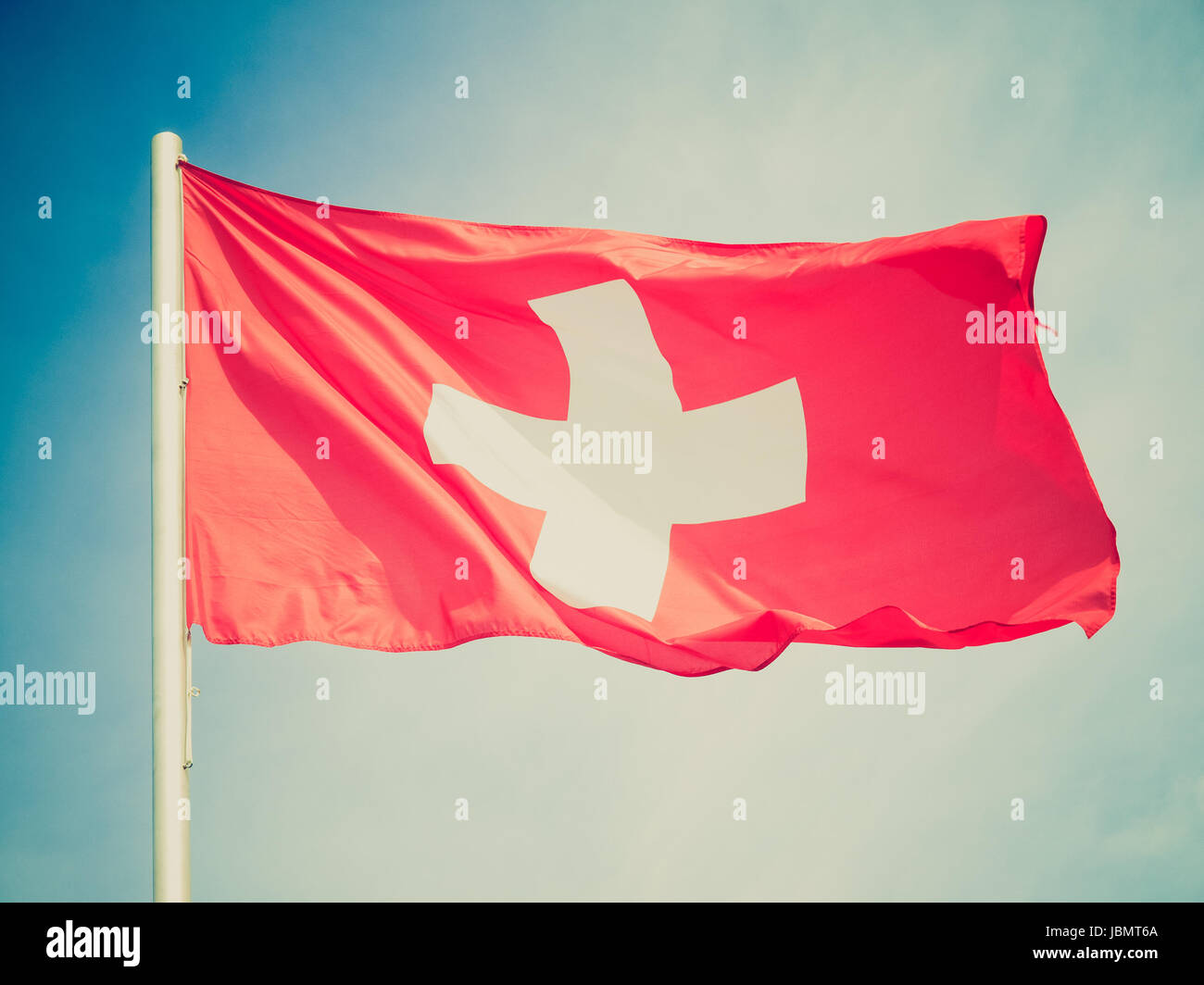 Vintage retro looking Flag of Switzerland over a blue sky Stock Photo ...