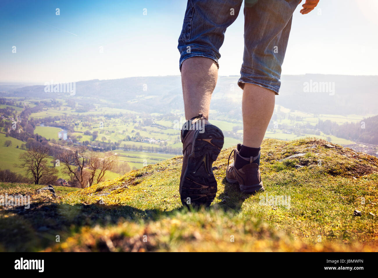 Hiker hiking on a mountain trail with distant views of countryside in ...