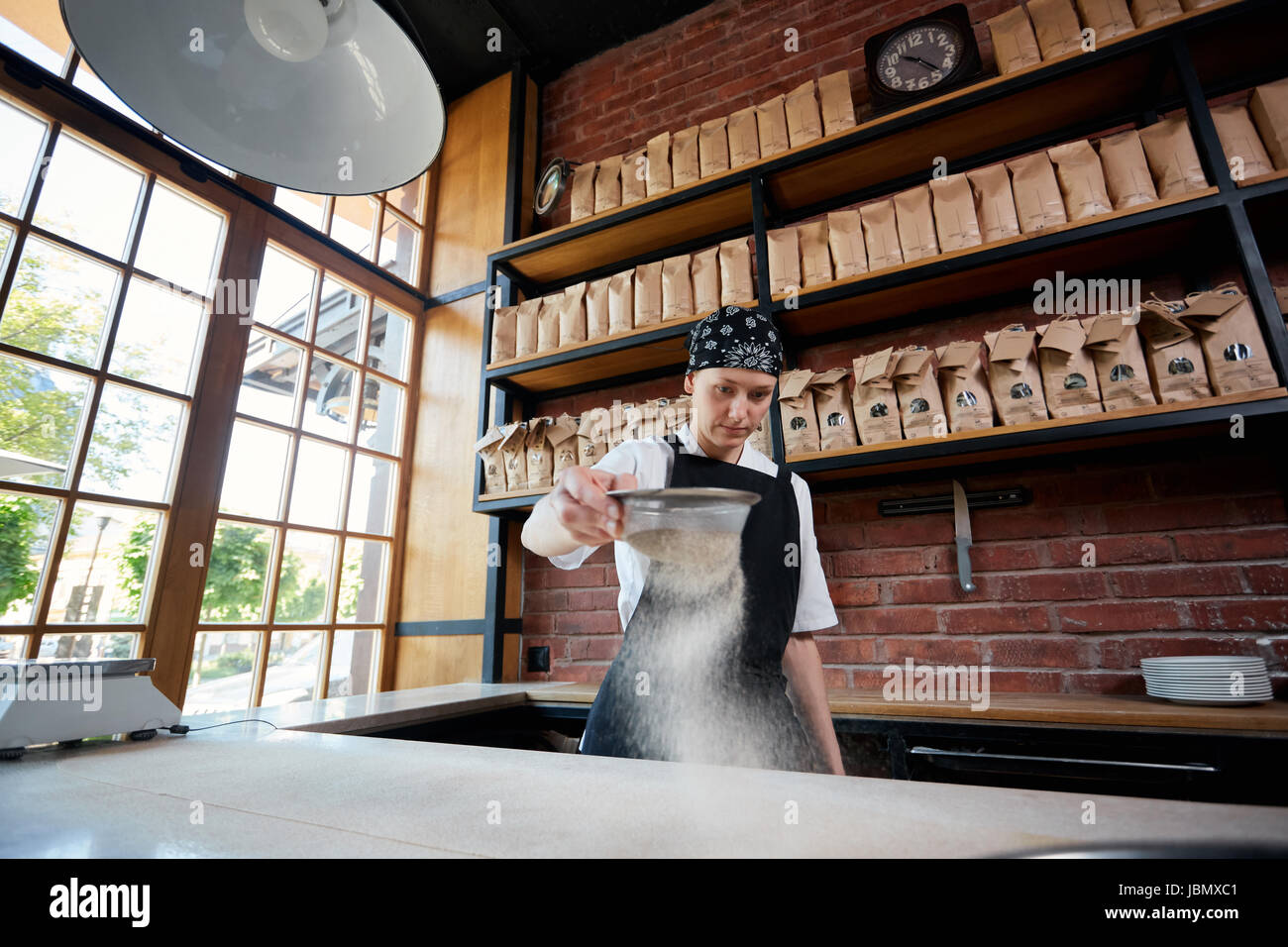 Woman add flour to dough Stock Photo - Alamy