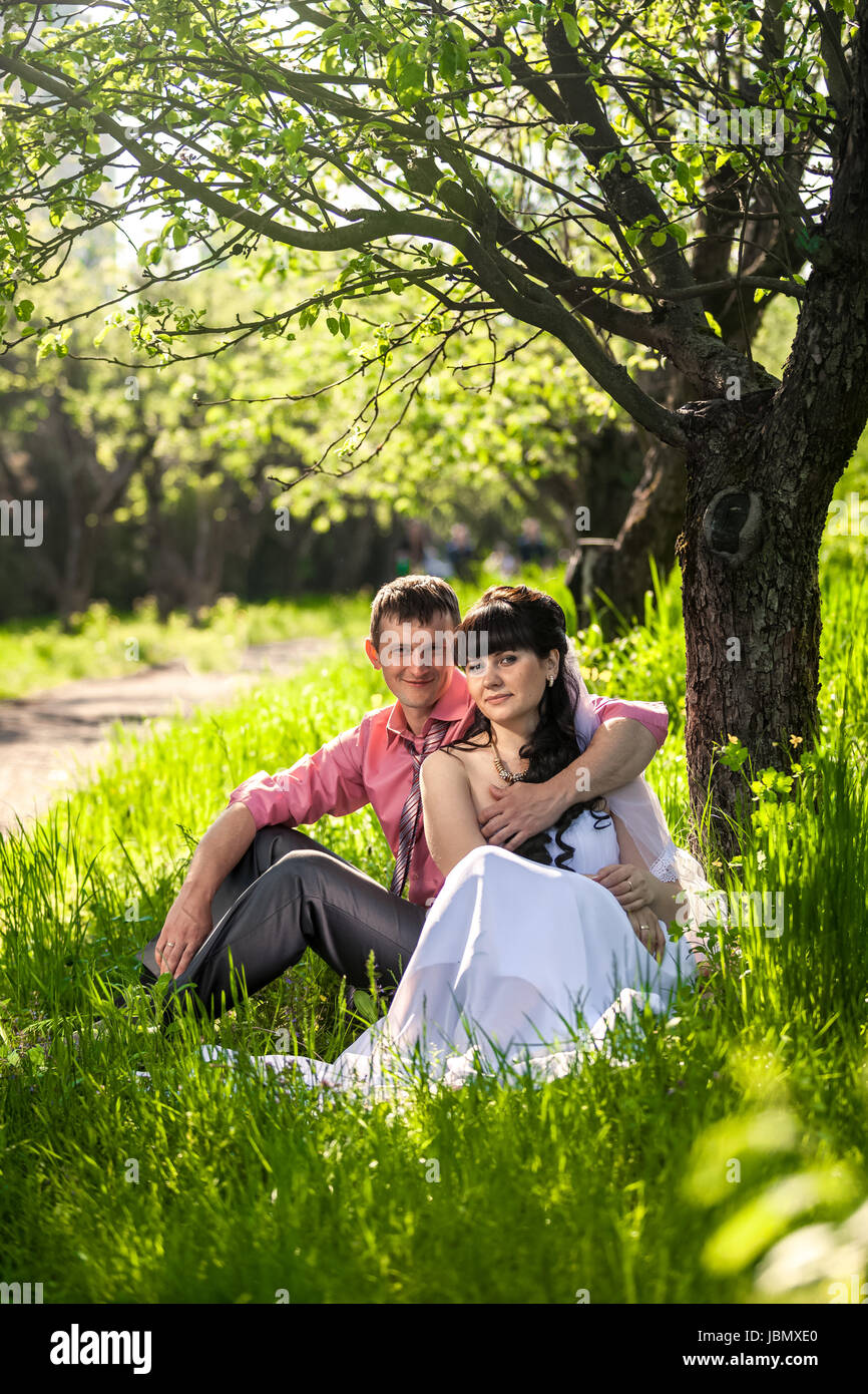 Portrait of newly married couple hugging under tree at alley Stock ...