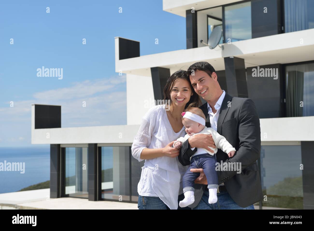 happy young family couple with beautiful new born baby have fun at home ...