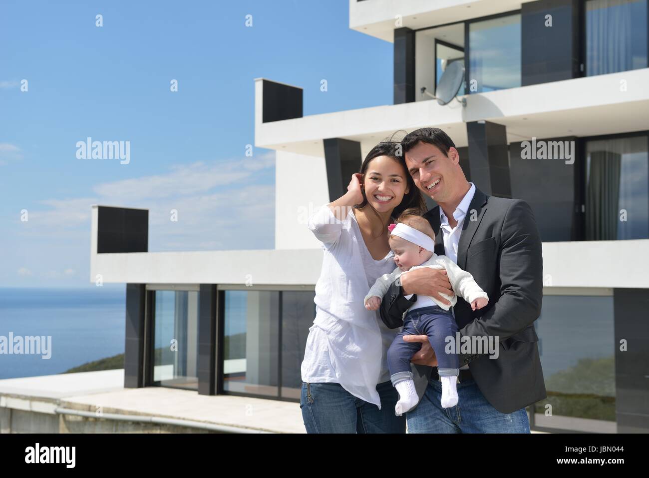 happy young family couple with beautiful new born baby have fun at home ...