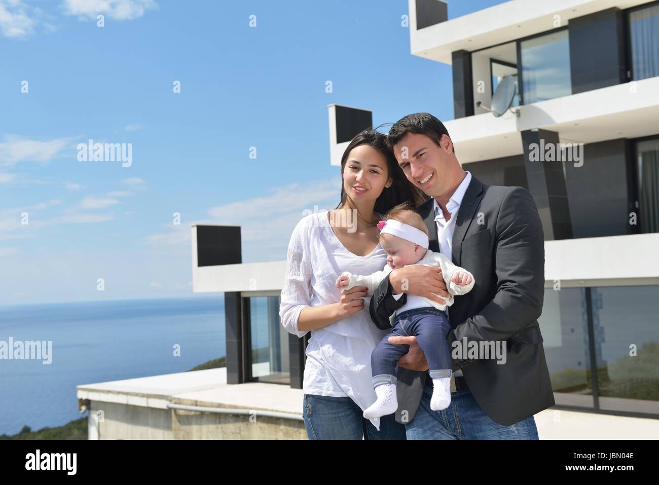 happy young family couple with beautiful new born baby have fun at home ...