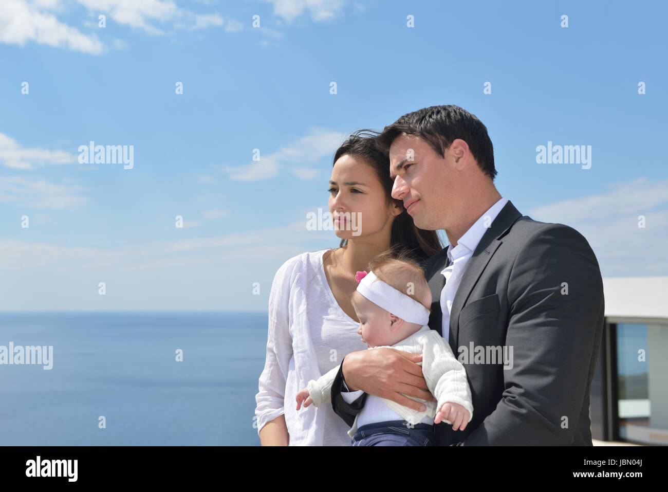 happy young family couple with beautiful new born baby have fun at home ...