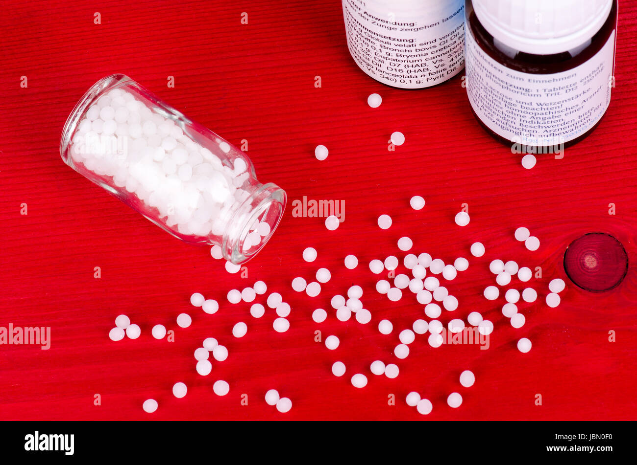 homeopathic globules on a red wooden background Stock Photo - Alamy