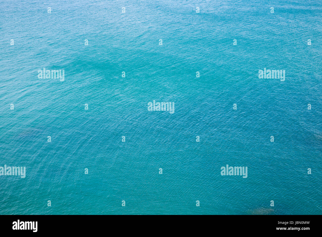 Blue water with sun reflections Stock Photo - Alamy